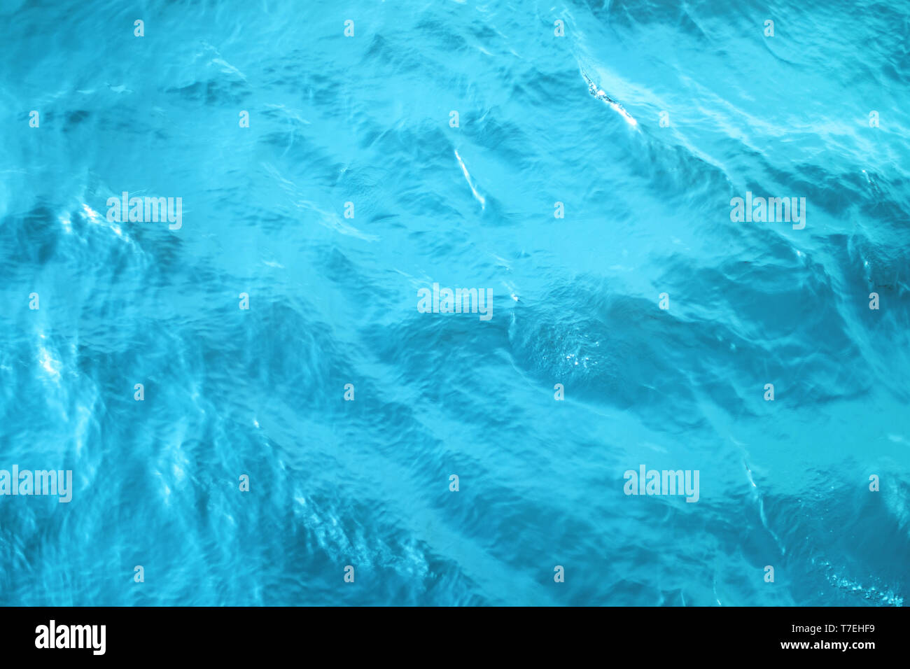 Closeup of calm river water surface with water splashes in blue color ...