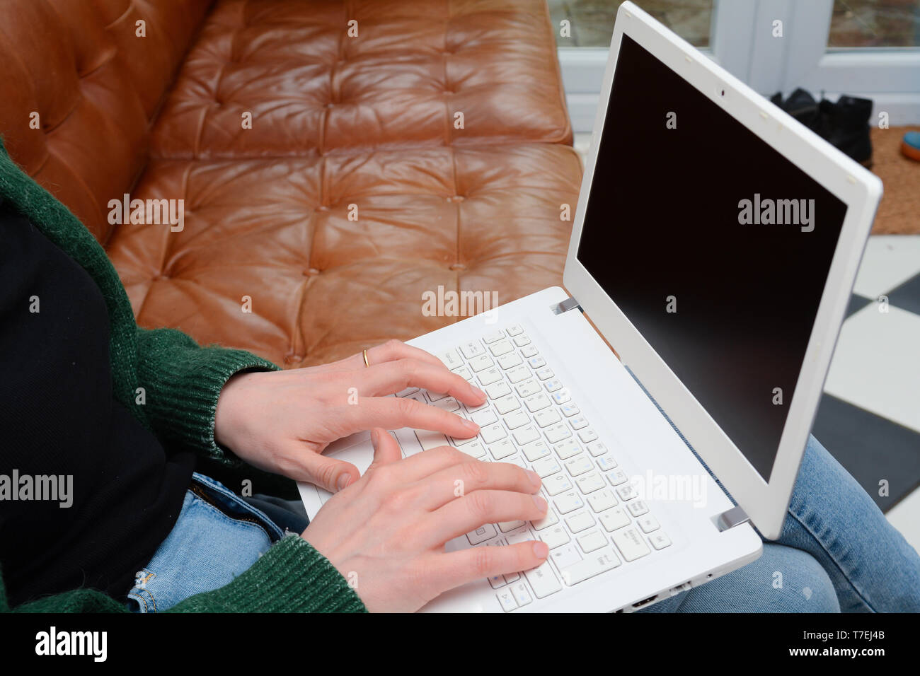 Woman at home using laptop computer whilst relaxing on the couch Stock ...