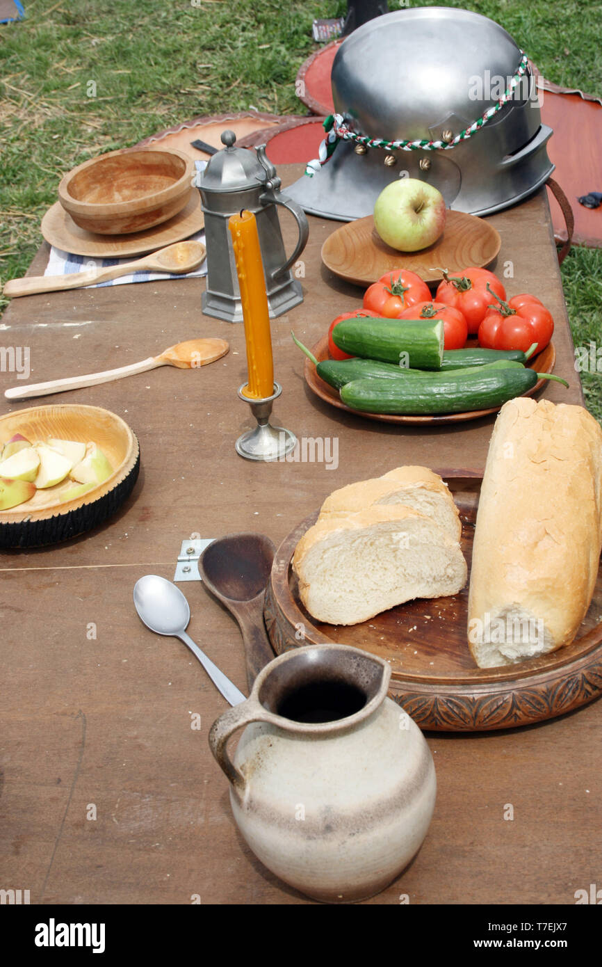 Medieval dining table with vegetables, candle and helmet Stock Photo ...