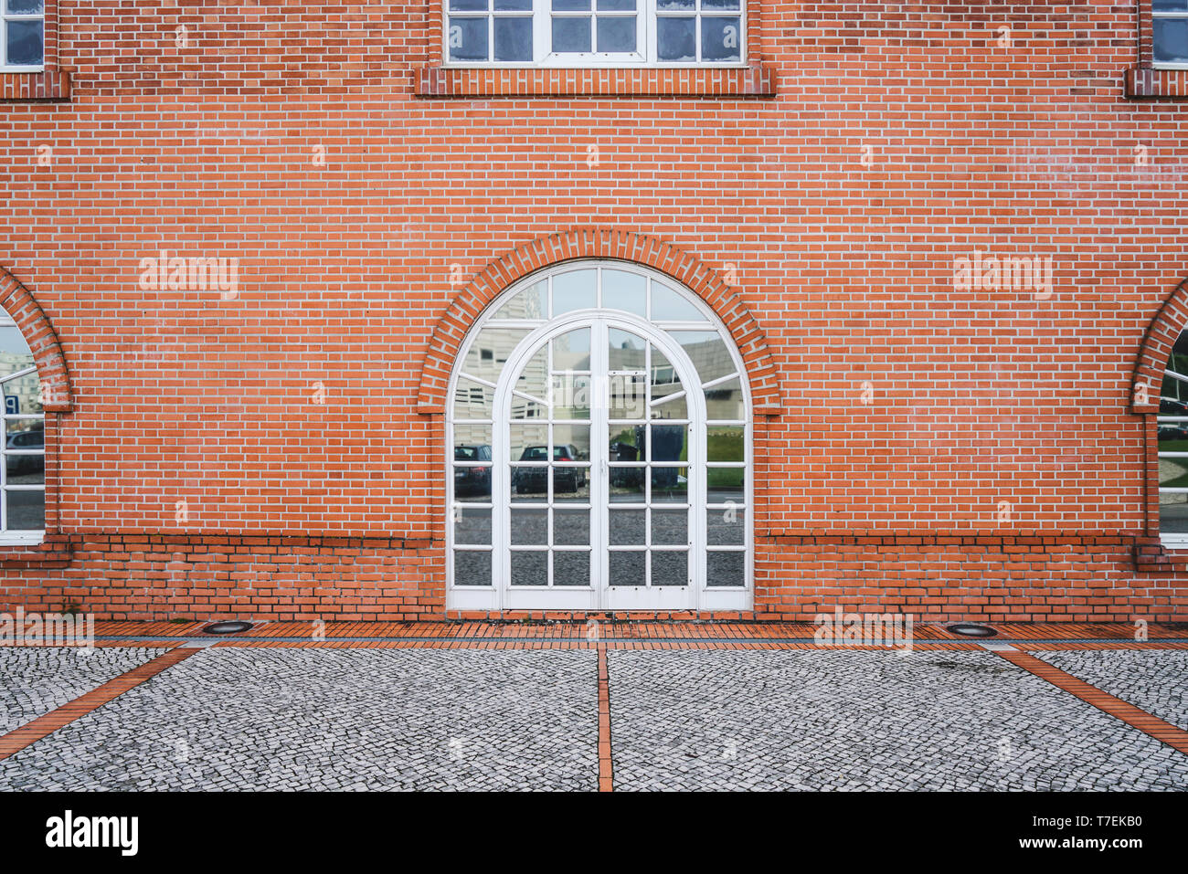 Red brick wall with beautiful white arch window. Detail of building ...