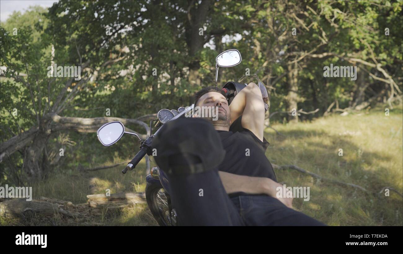 motorcyclist guy lying on a motorcycle Stock Photo - Alamy