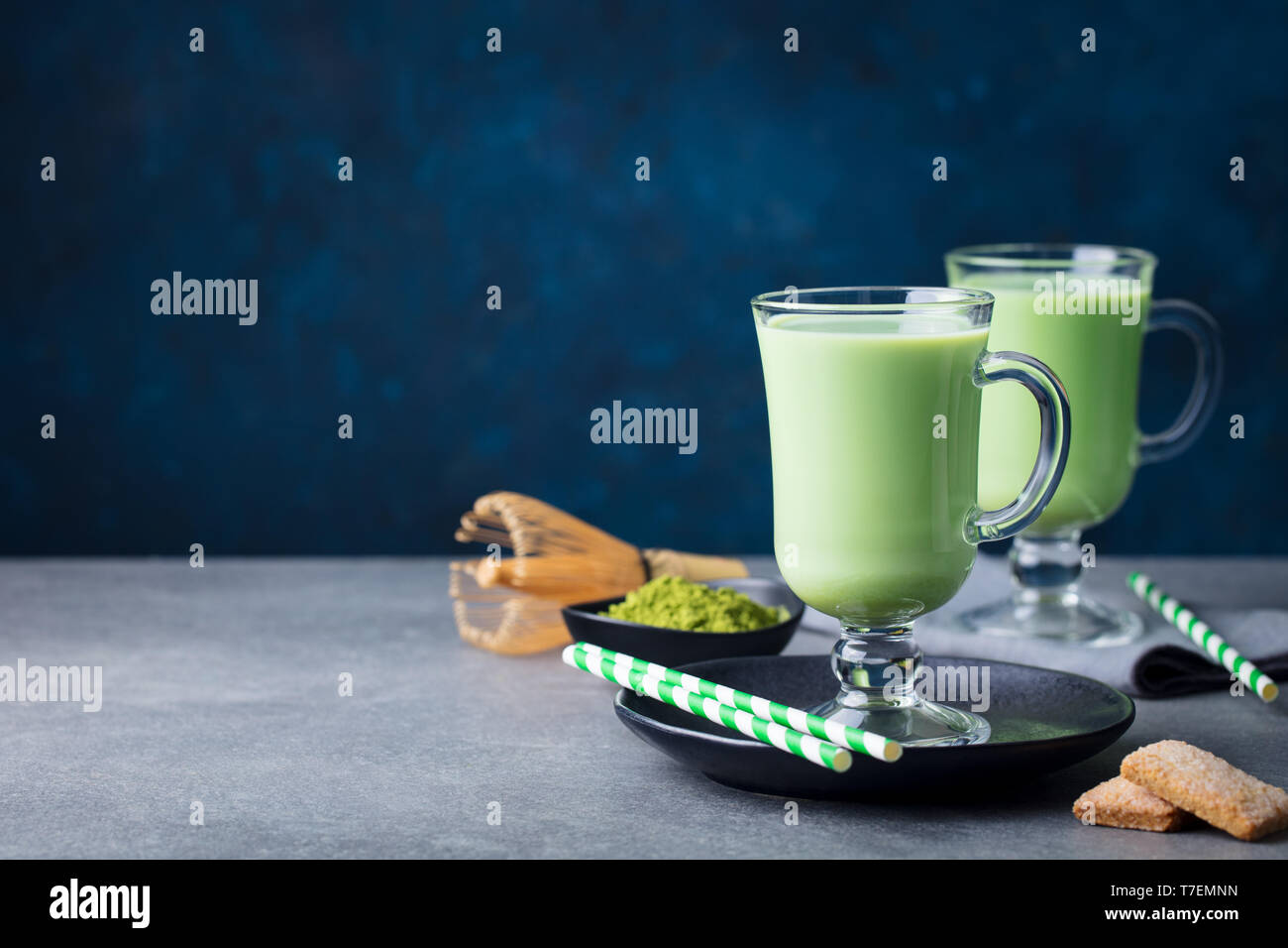 Matcha green tea latte with matcha powder and bamboo whisk. Grey stone ...