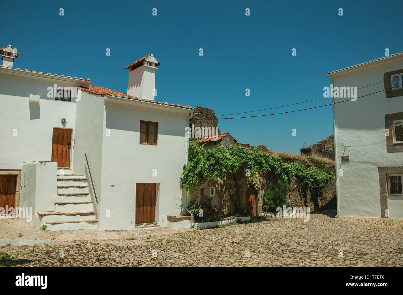 Old whitewashed houses in front of cobblestone square at Castelo de ...