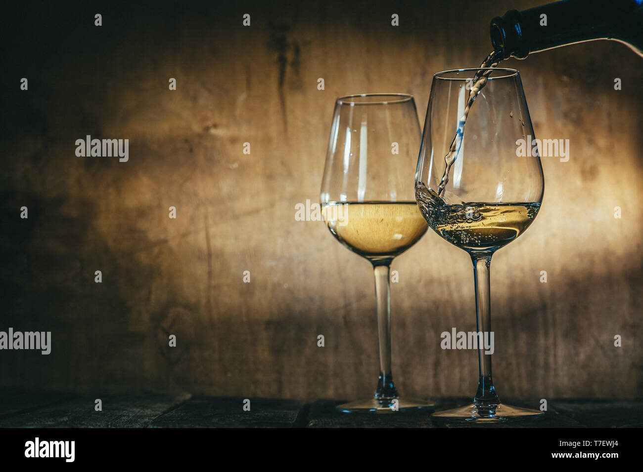 White wine in glasses on rustic background Stock Photo - Alamy