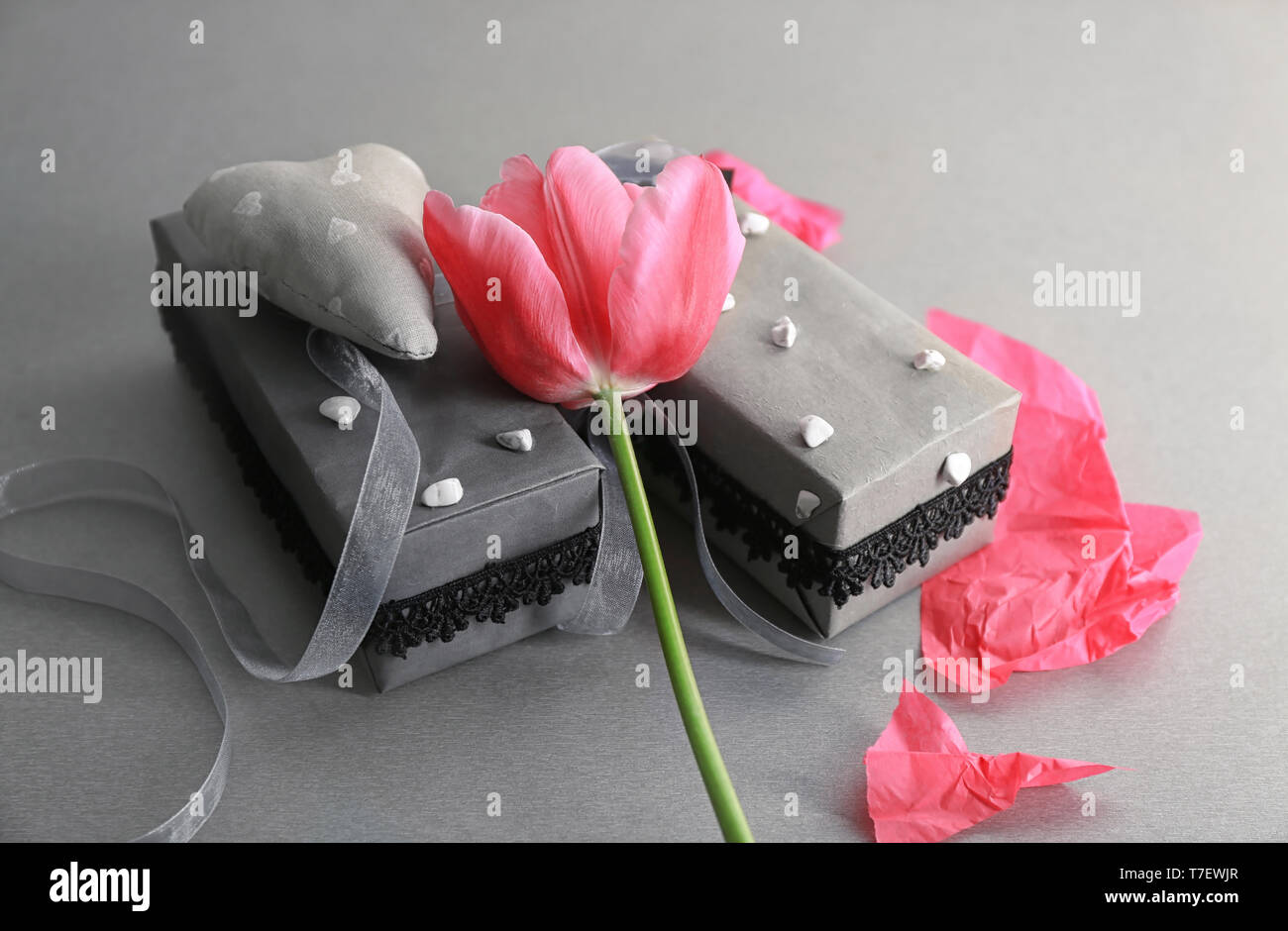 Stylish gift boxes and tulip on grey background Stock Photo - Alamy