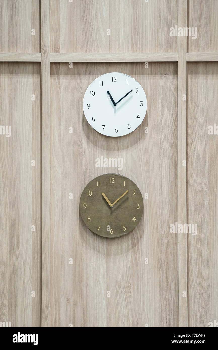 two difference clocks hang on to wooden background Stock Photo - Alamy