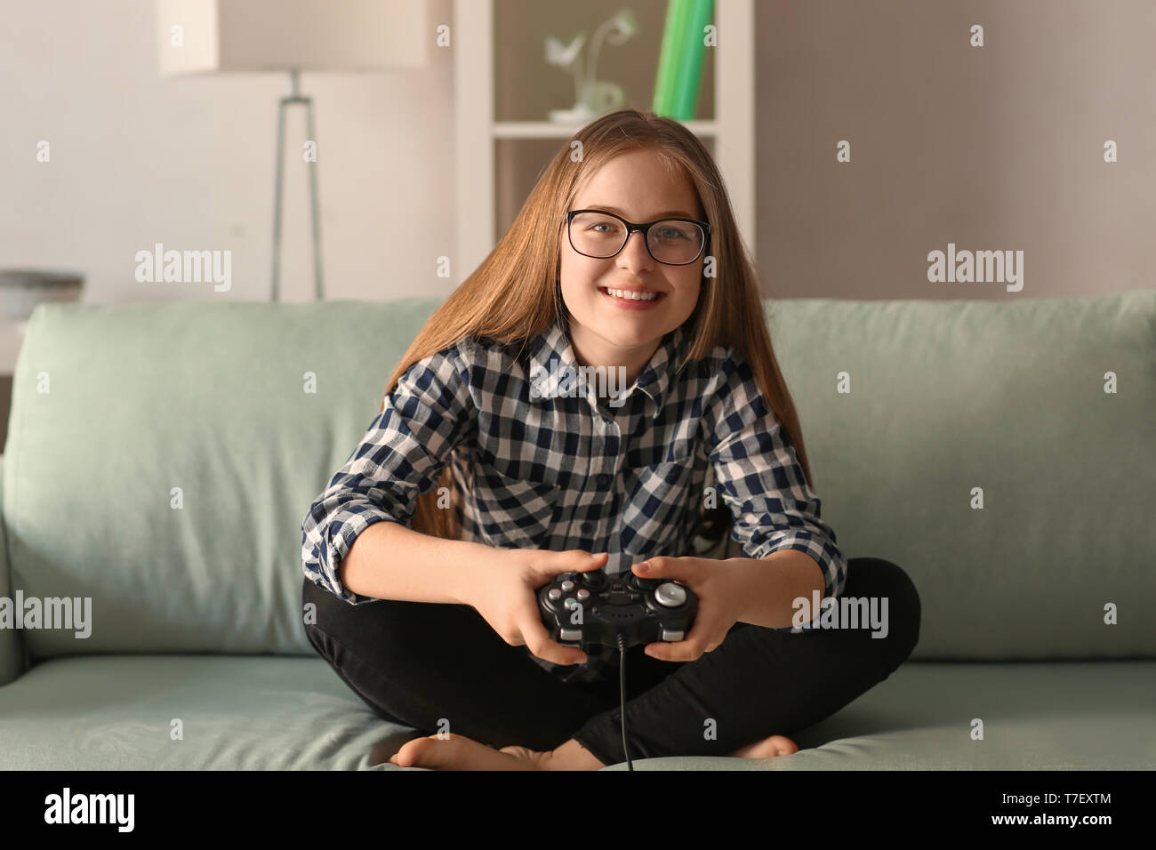 Cute girl playing video games at home Stock Photo - Alamy