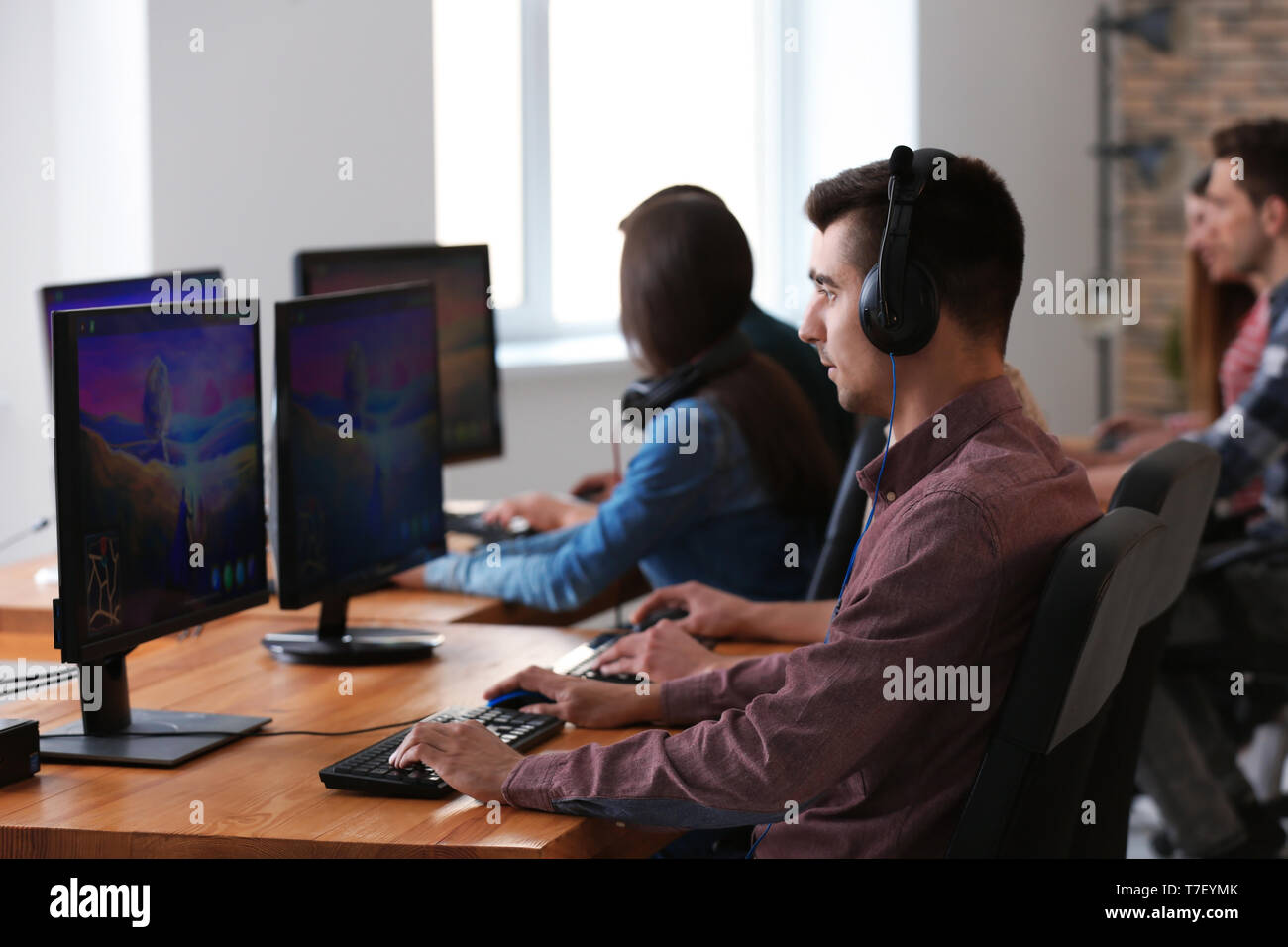 Young people playing video games at tournament Stock Photo - Alamy