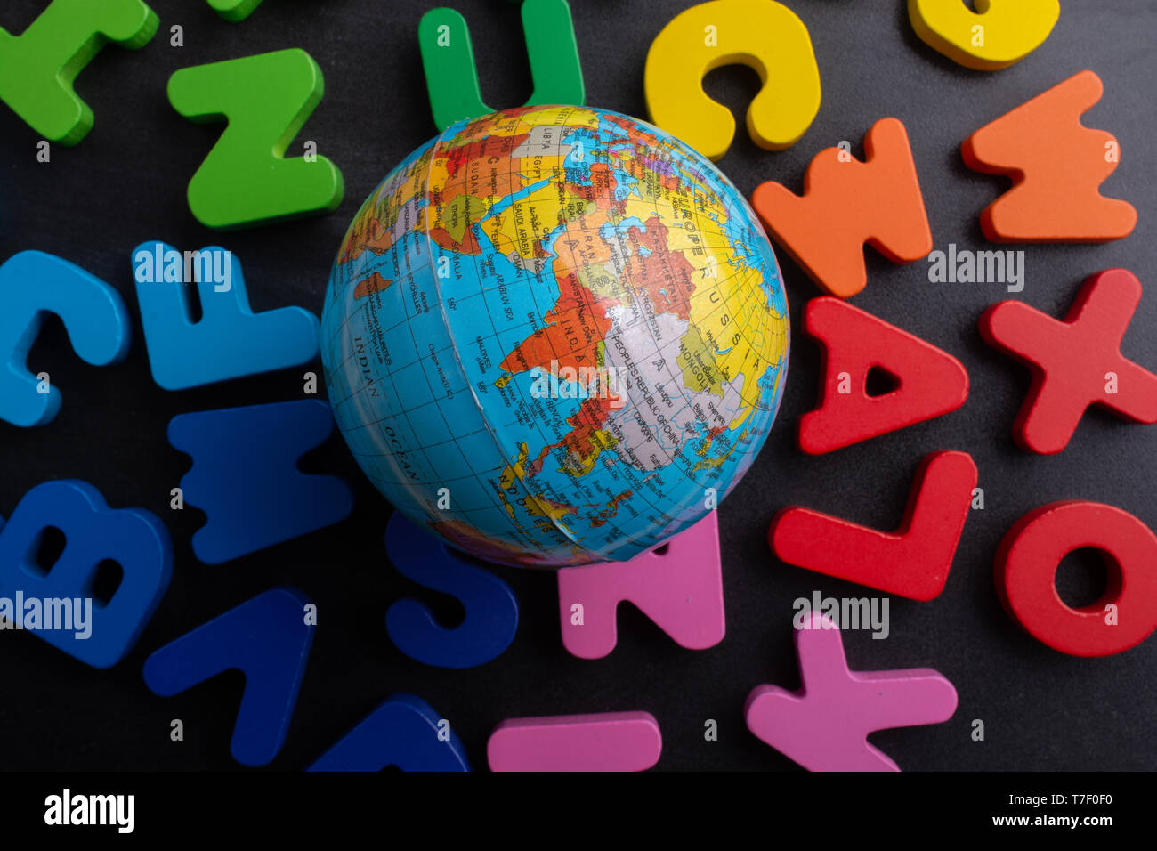 Earth globe model on colorful letters on a black background Stock Photo ...