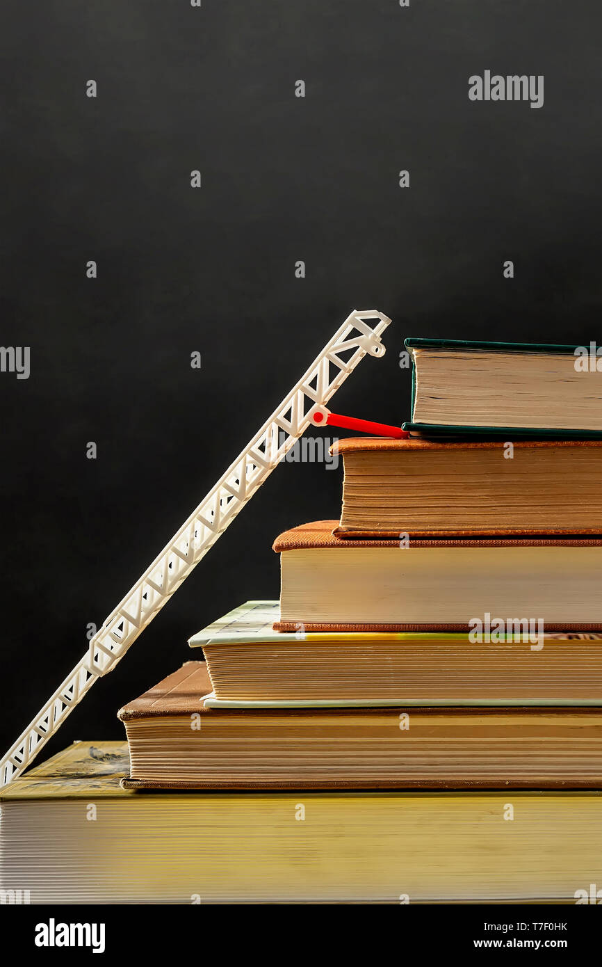 Back to school concept. Stack steps stairs of old books. Toy fire ...