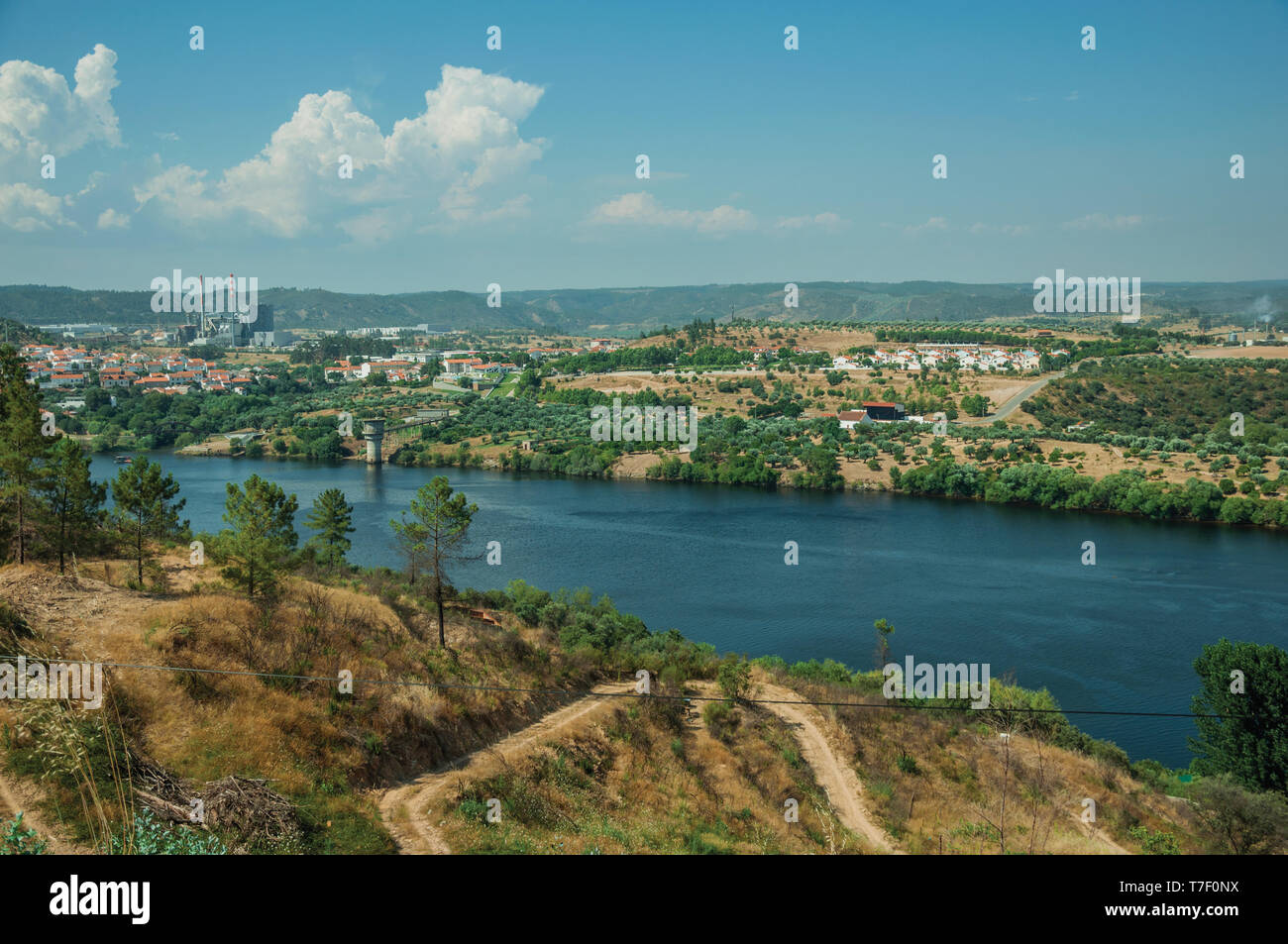 Tejo River valley with hills covered by undergrowth and industry on ...