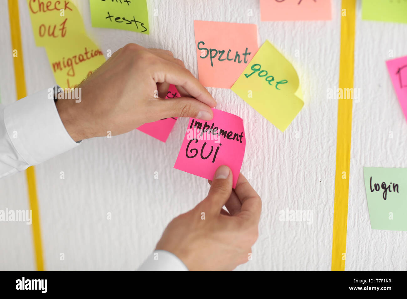 Man with sticker near scrum task board in office Stock Photo - Alamy
