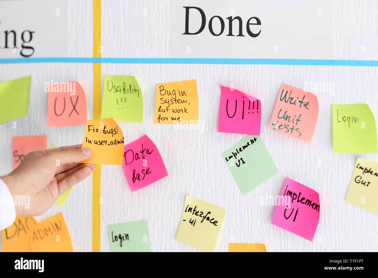 Man with sticker near scrum task board in office Stock Photo - Alamy