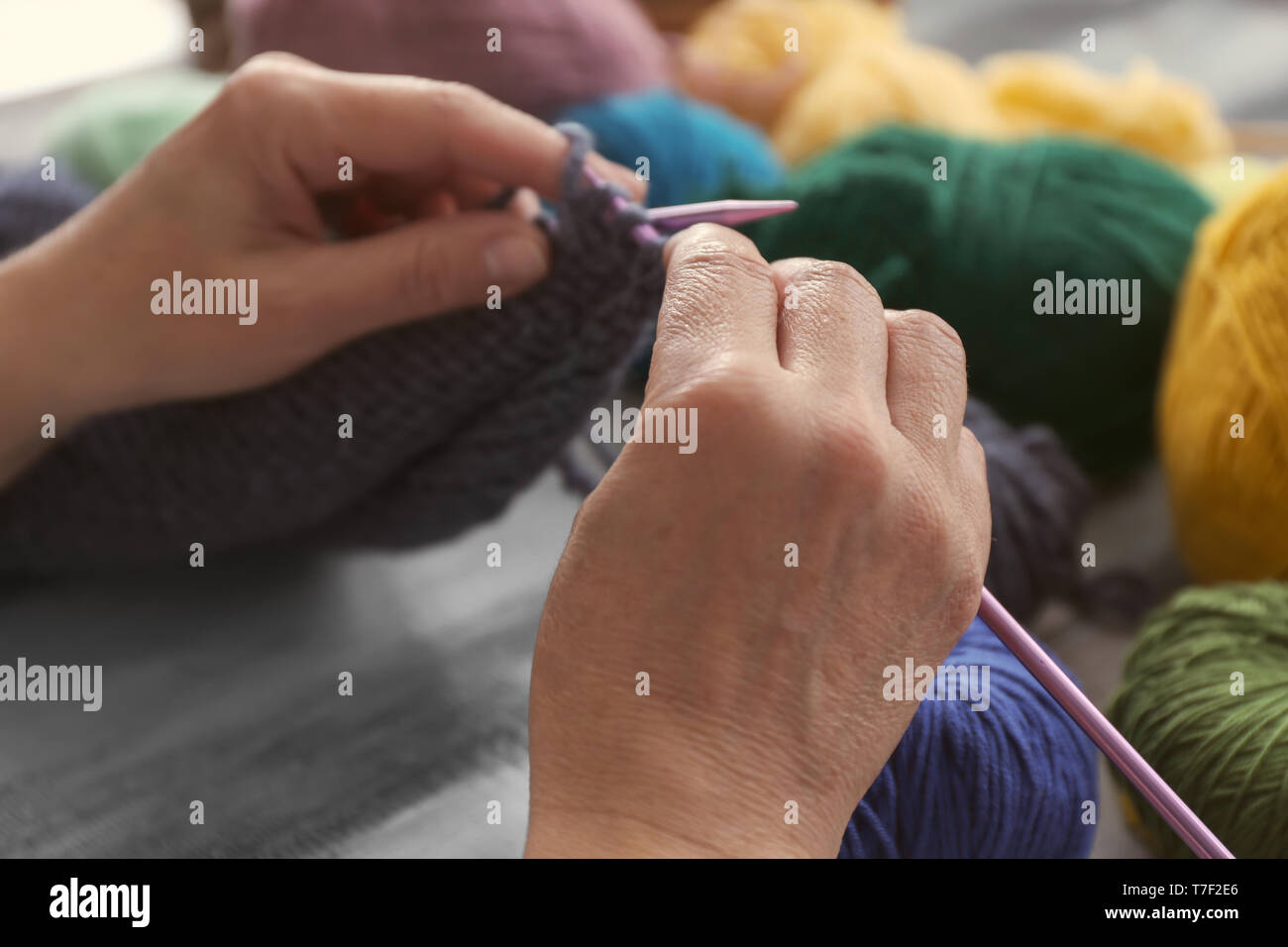 Mature woman knitting warm sweater at table, closeup Stock Photo - Alamy