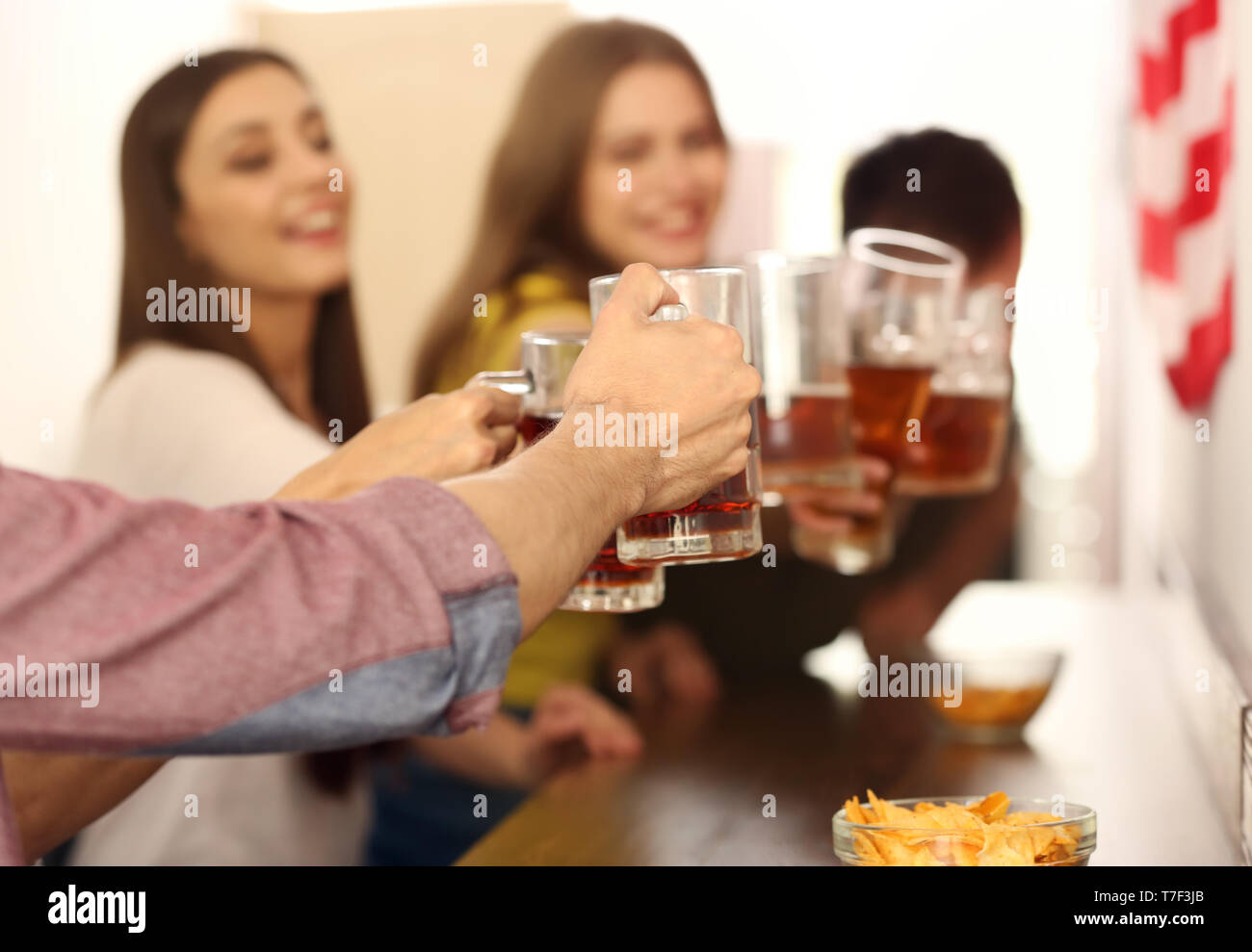 Group of friends clinking glasses with beer in bar Stock Photo - Alamy
