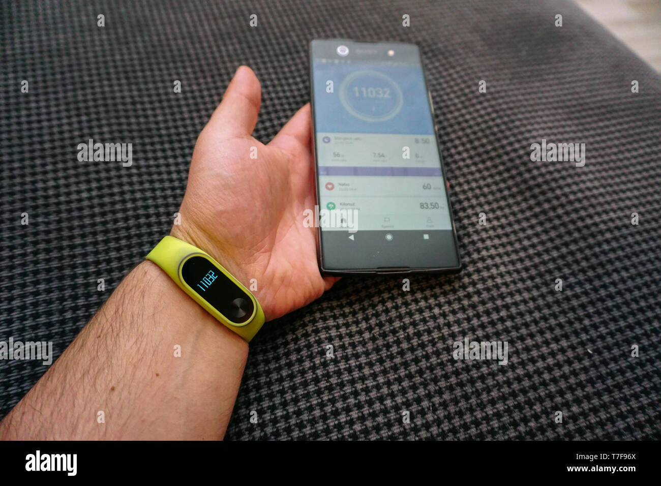 Smartphone and fitness activity tracker bracelet on the wrist close up ...