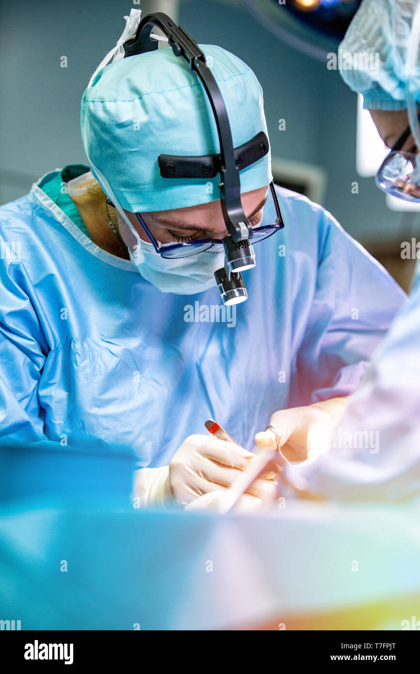 Surgeon and his assistant performing cosmetic surgery on nose in ...
