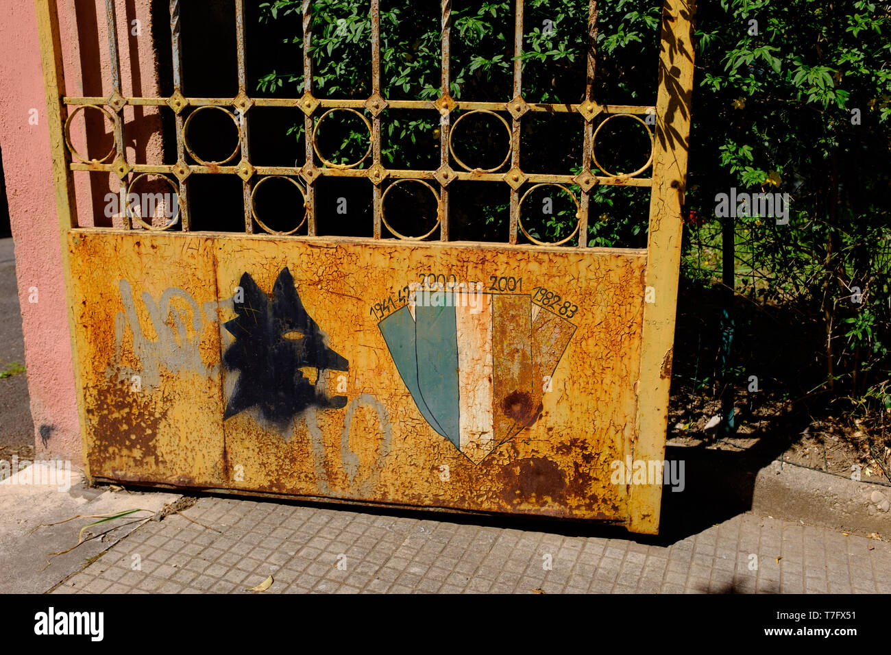 The Capitoline Wolf and Italian flag symbols, painted on to a gate in ...