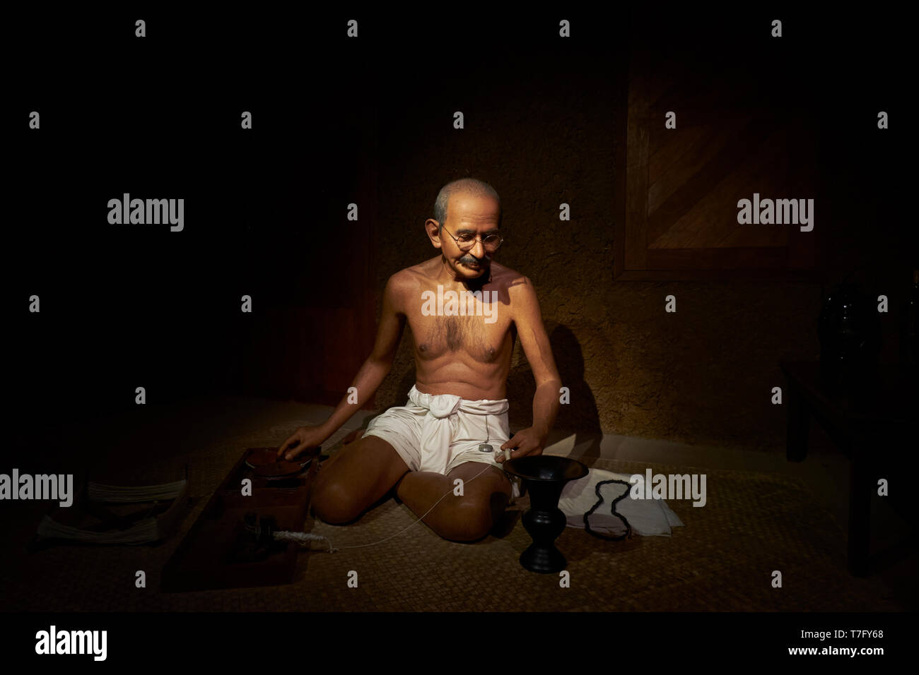 Fiberglass model of India leader Gandhi weaving under dramatic lighting ...