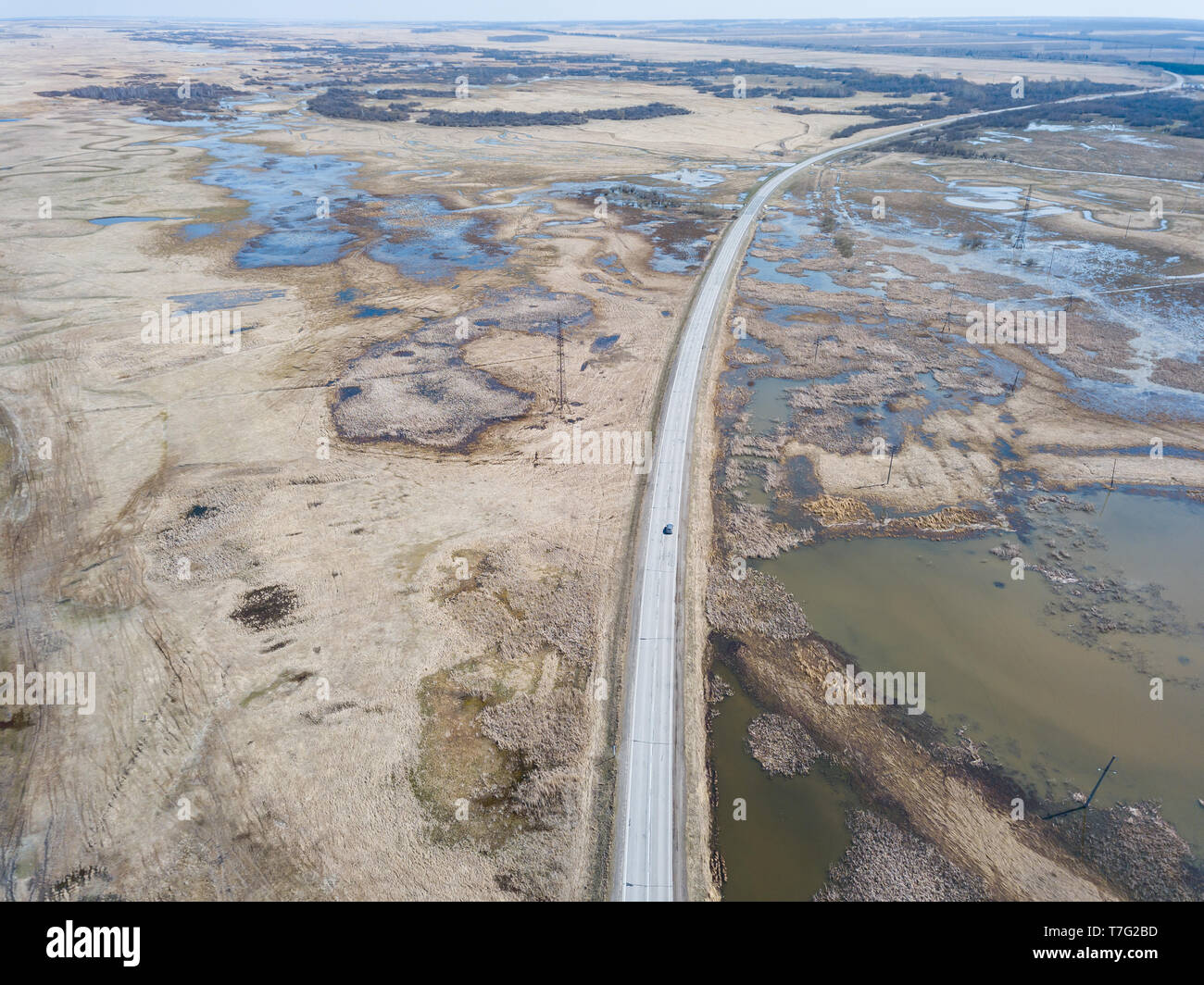 Aerial view of a marshland near a highway with an asphalt road during a ...