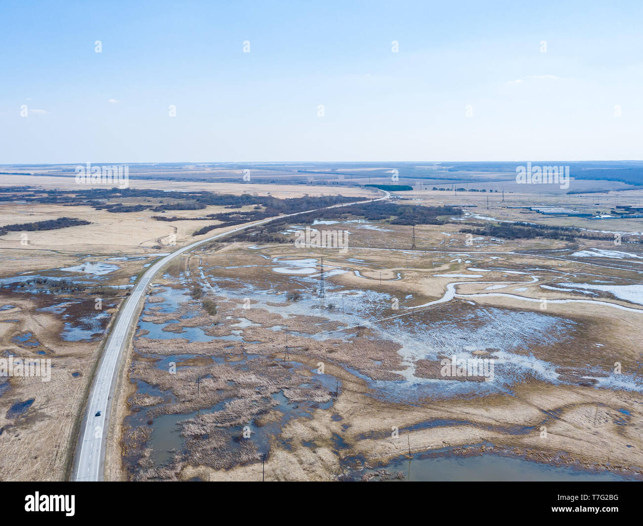 Aerial view of a marshland near a highway with an asphalt road during a ...