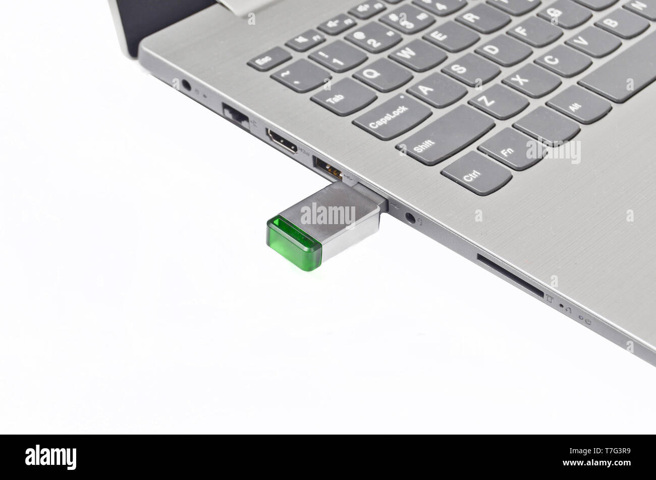 USB flash drive inserted into a laptop isolated on a white background ...