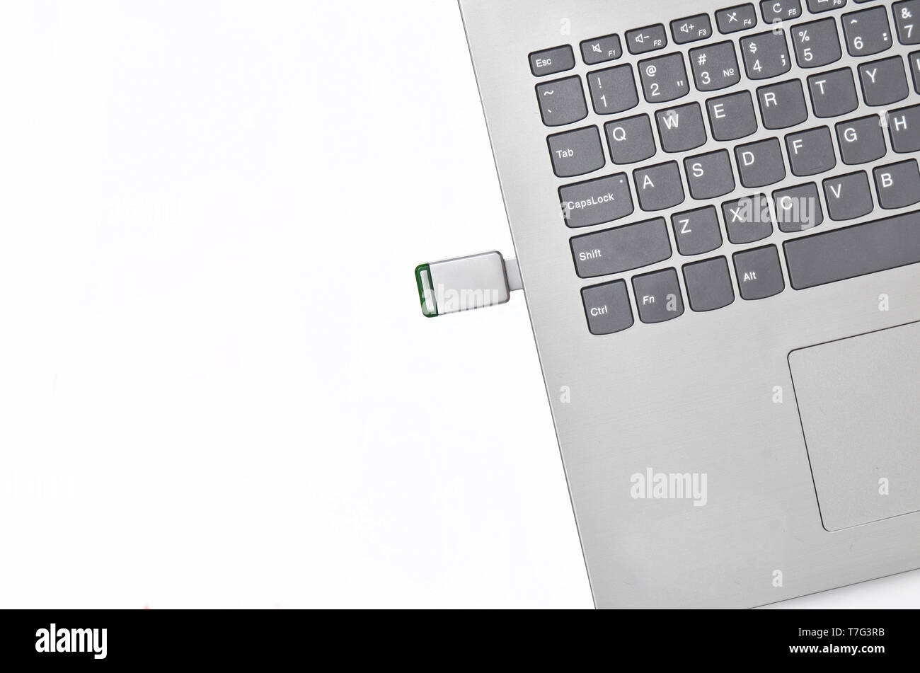 USB flash drive inserted into a laptop isolated on a white background ...