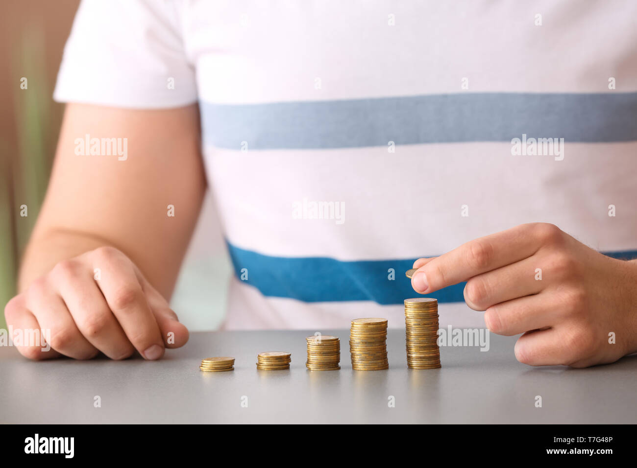 Man stacking coins on table. Savings concept Stock Photo - Alamy