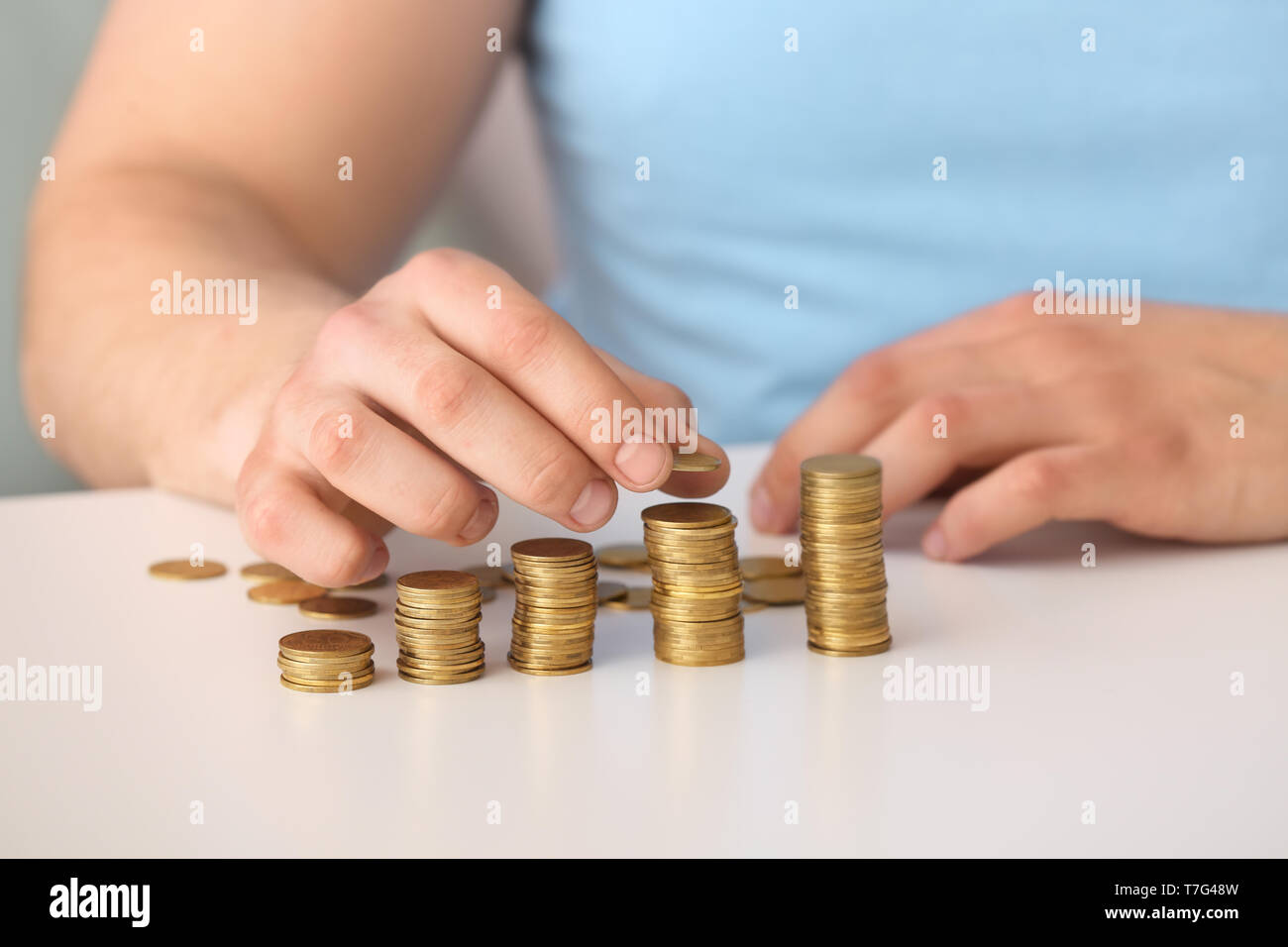 Man stacking coins on table. Savings concept Stock Photo - Alamy