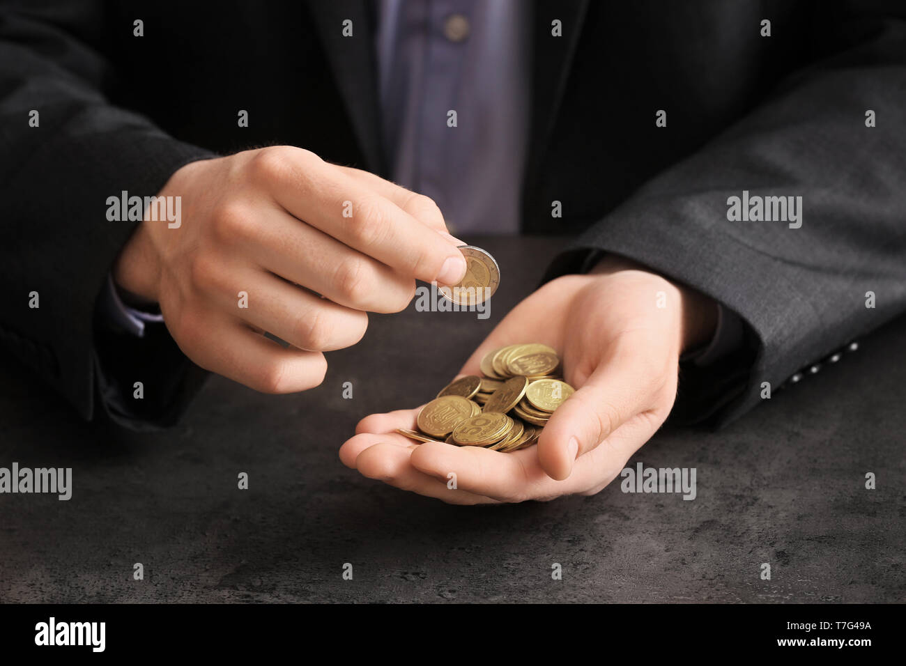 Man counting coins at table. Savings concept Stock Photo - Alamy