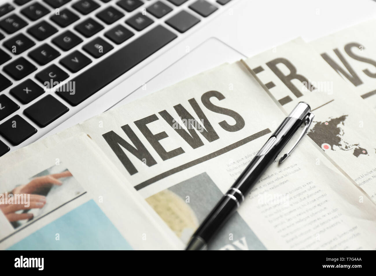 Newspaper, pen and laptop, closeup Stock Photo - Alamy