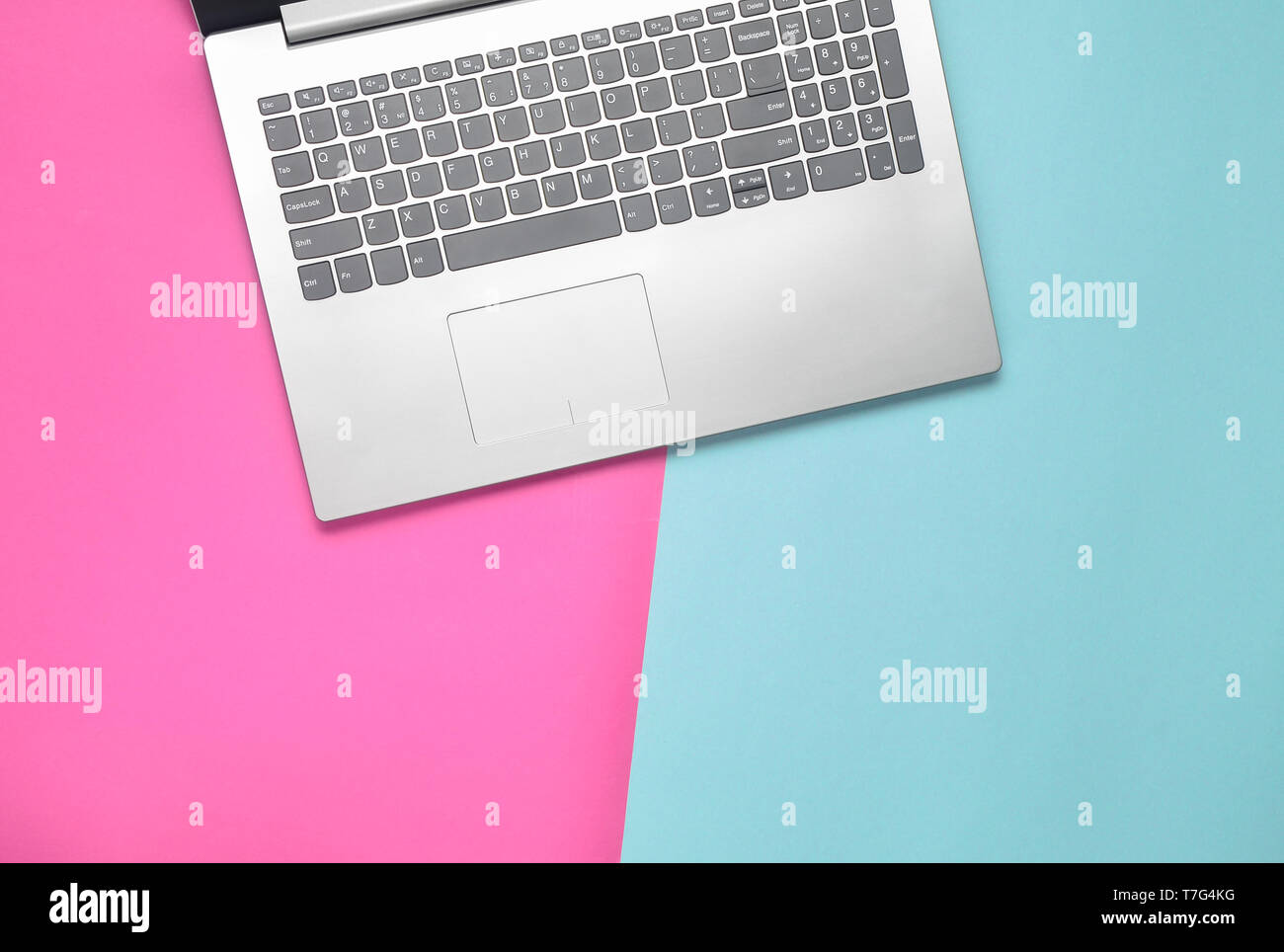 Fragment of a laptop on a colored paper background. Keyboard, touchpad ...