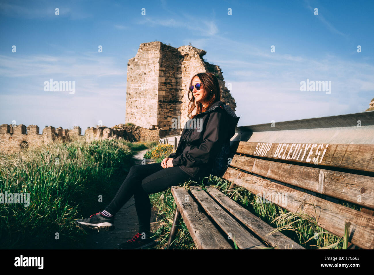 Girl with sunglasses sitting on a bench sunbathing on sinop Stock Photo ...