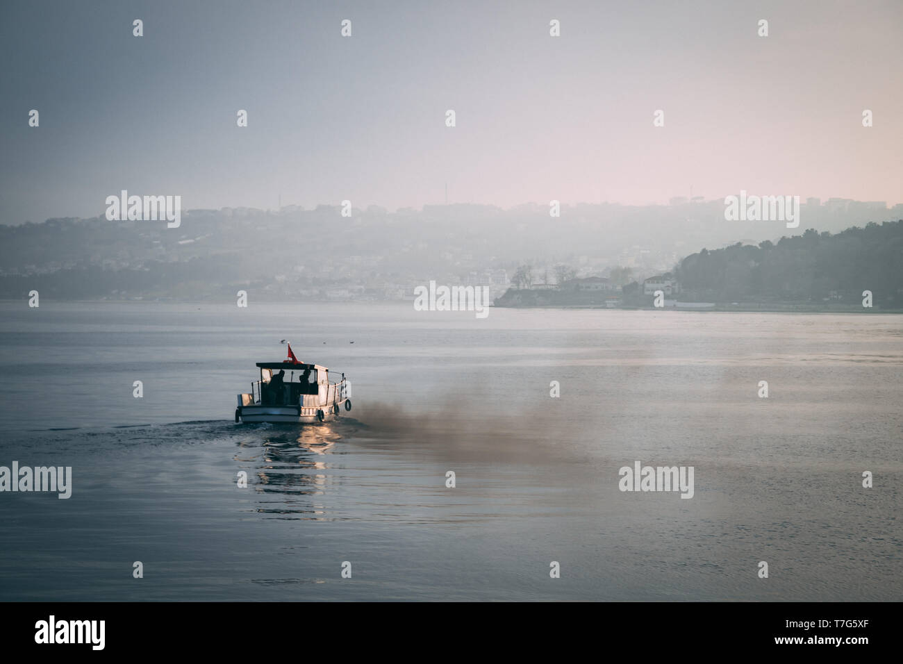 small boat filling the air with smoke and pollution from his engine ...