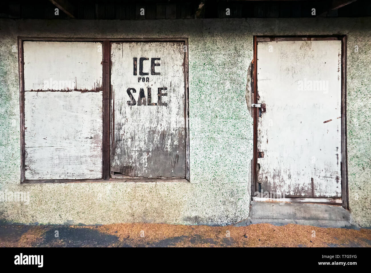 Facade of a rundown shop with closed wooden window and door at the ...