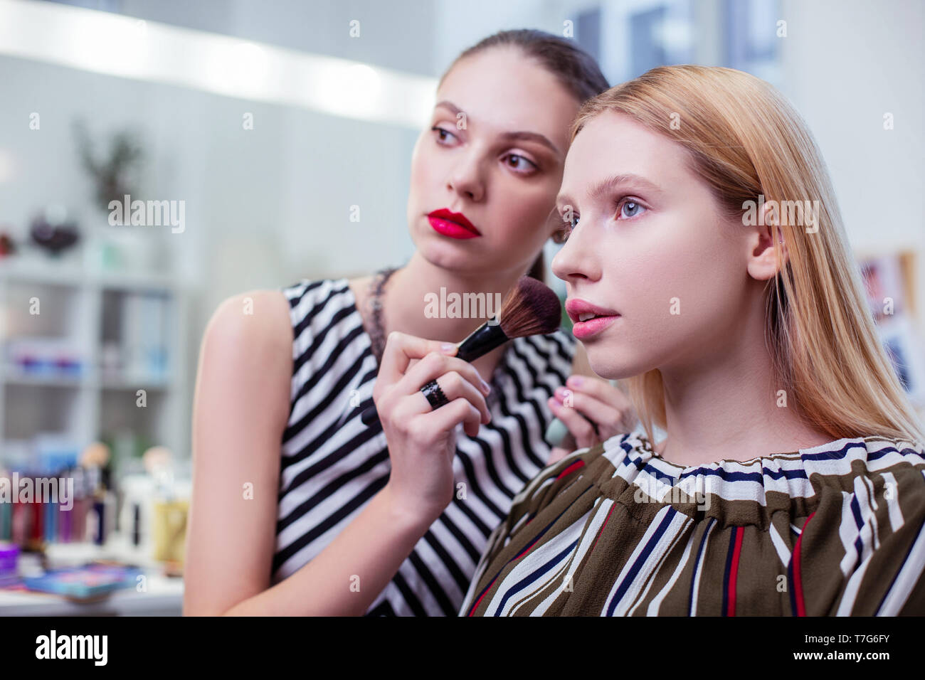 Pleasant blonde woman speaking with her visagiste Stock Photo - Alamy