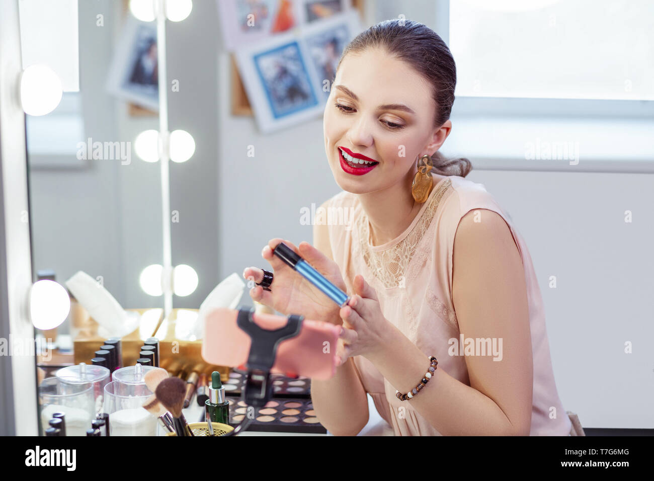 Positive pretty woman holding her professional mascara Stock Photo - Alamy
