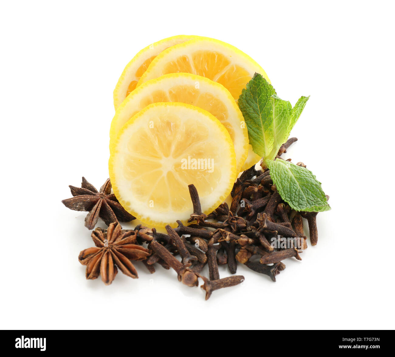 Dry cloves with anise stars, mint and sliced lemon on white background ...