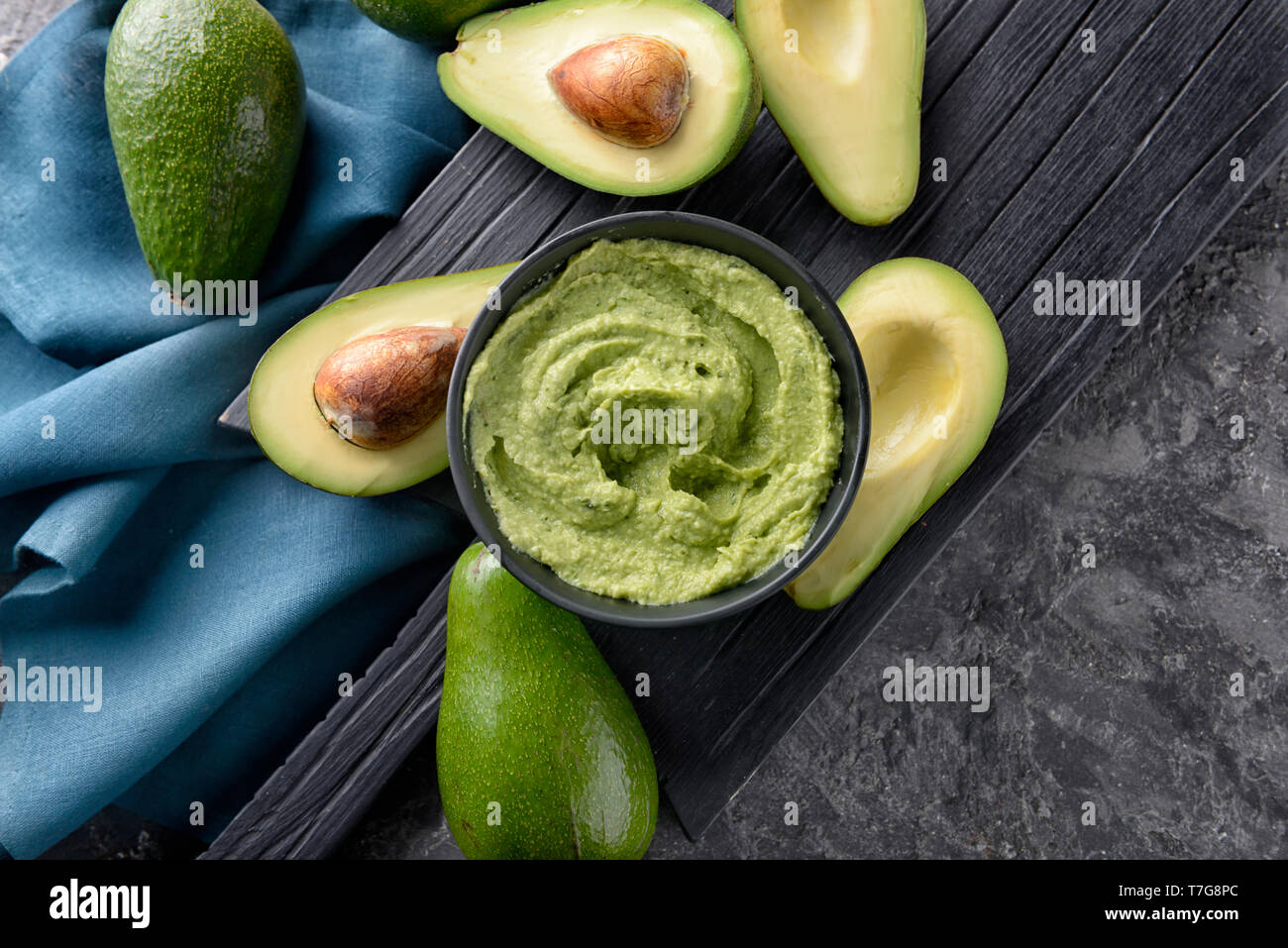 Bowl with delicious guacamole on board Stock Photo - Alamy