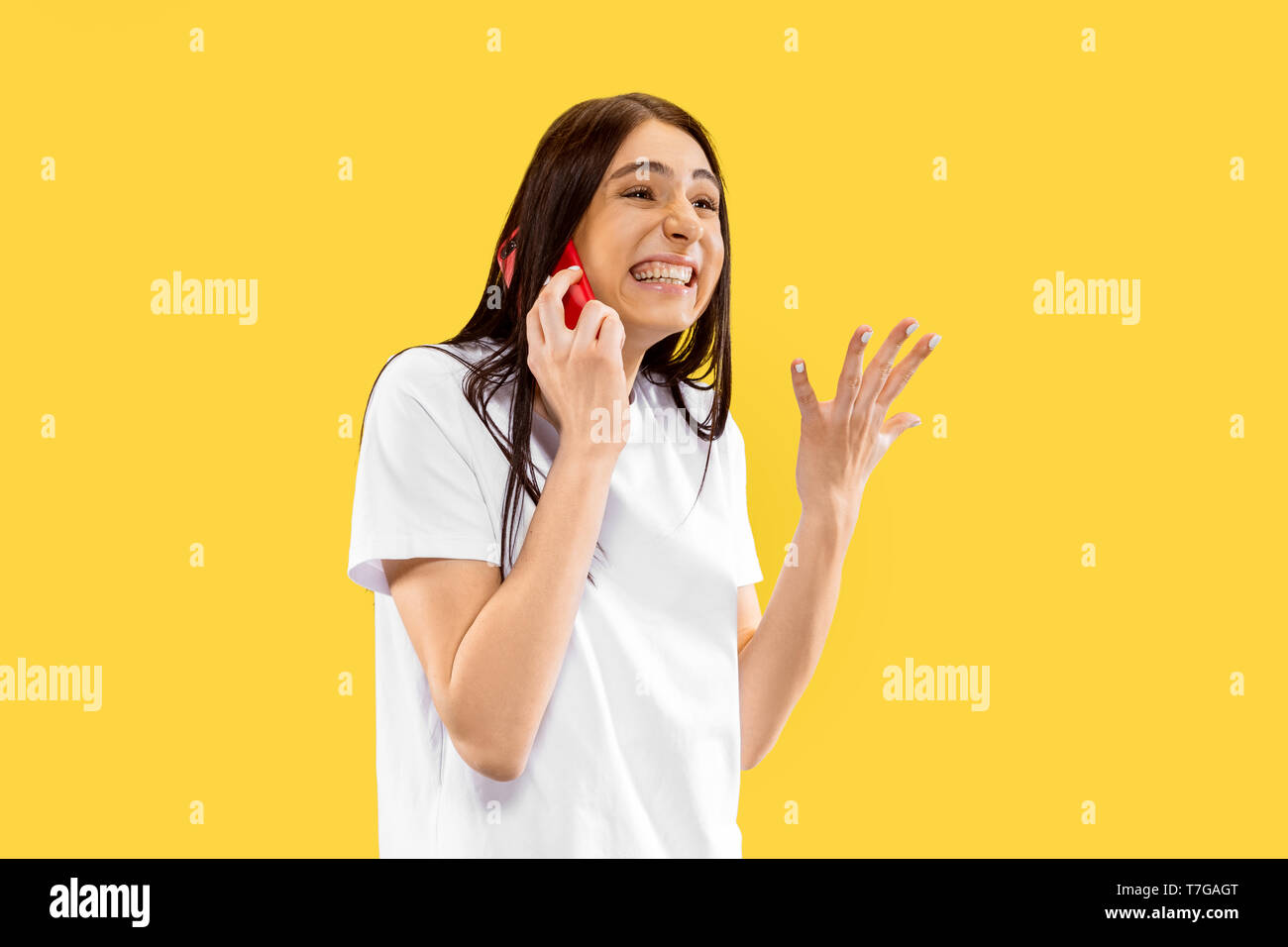 Astonished girl talking on the phone. Beautiful female half-length ...