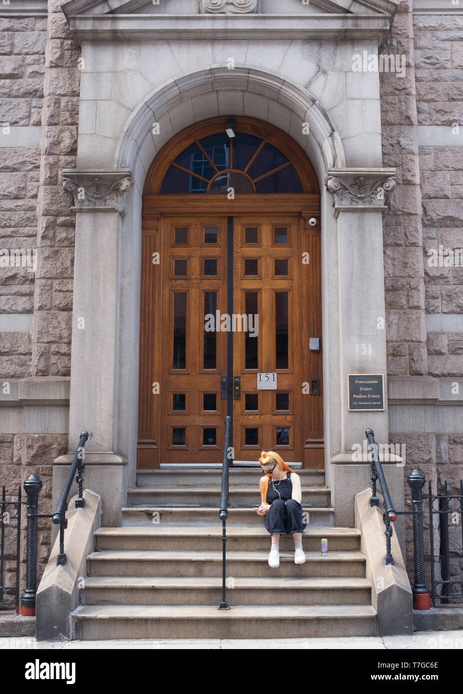 Young woman sitting on steps of church in Manhattan,New York City, New ...