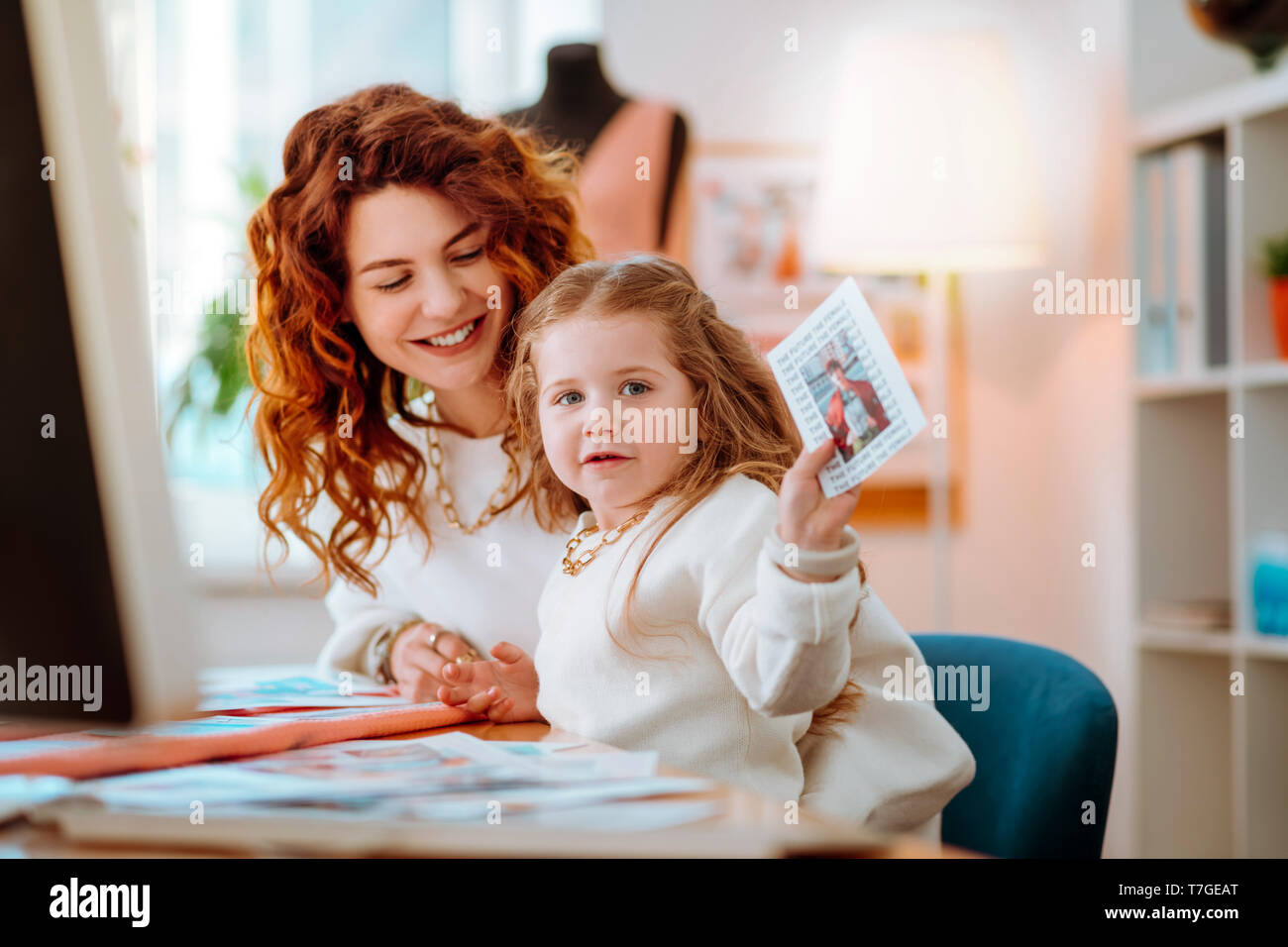 Designer looking at her lovely daughter visiting her in workshop Stock ...