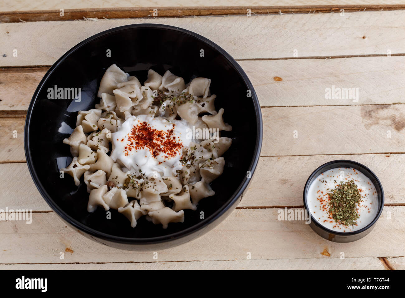 turkish manti in a black plate on wooden background Stock Photo - Alamy