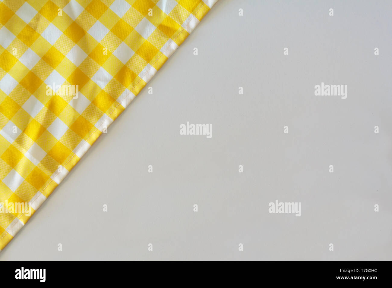 Yellow picnic tablecloth on white background with copy space Stock ...