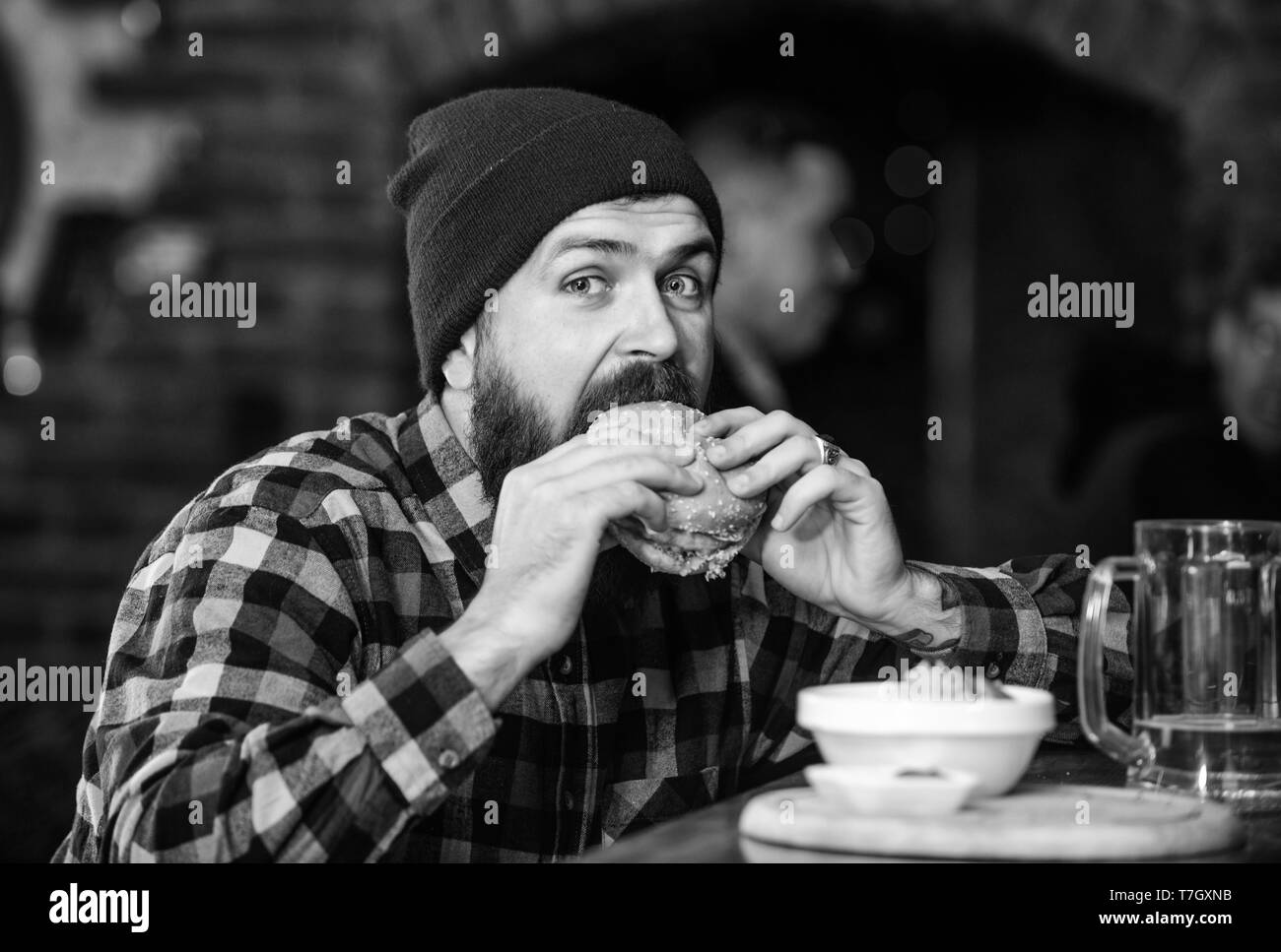 Brutal hipster bearded man sit at bar counter. High calorie food. Cheat ...