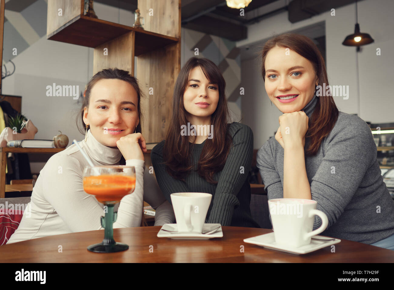 Three women sitting in a cafeteria hi-res stock photography and images ...