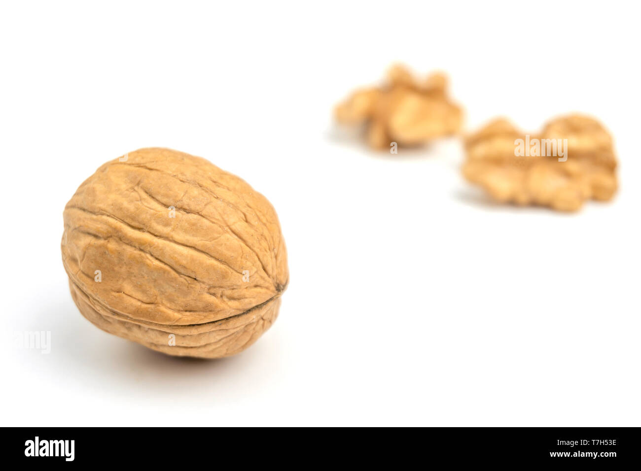 Close-up of a whole walnut and nut kernels out of focus in the ...
