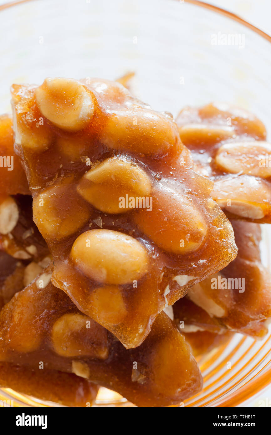 Peanut brittle pieces of hard sugar candy with peanuts Stock Photo - Alamy