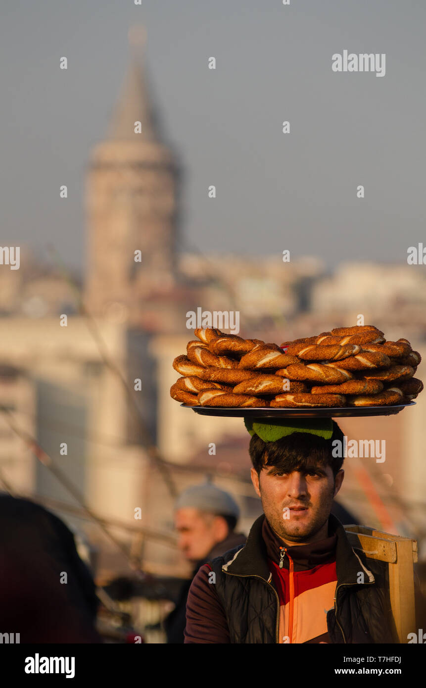 A Turkish man carries Simit on a tray on his head on the Galata Tower ...