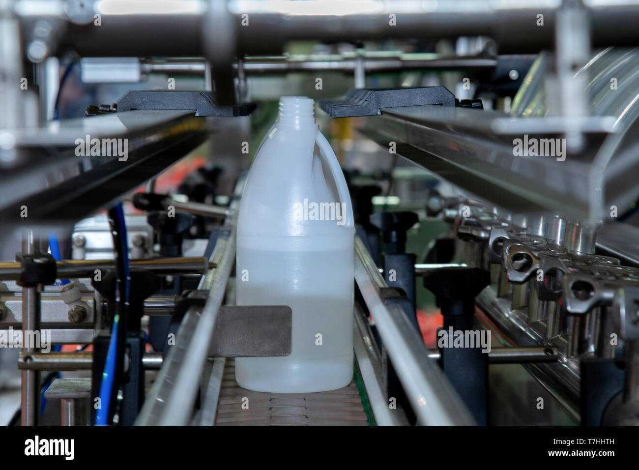 white plastic gallons or bottle on the production line of the conveyor ...